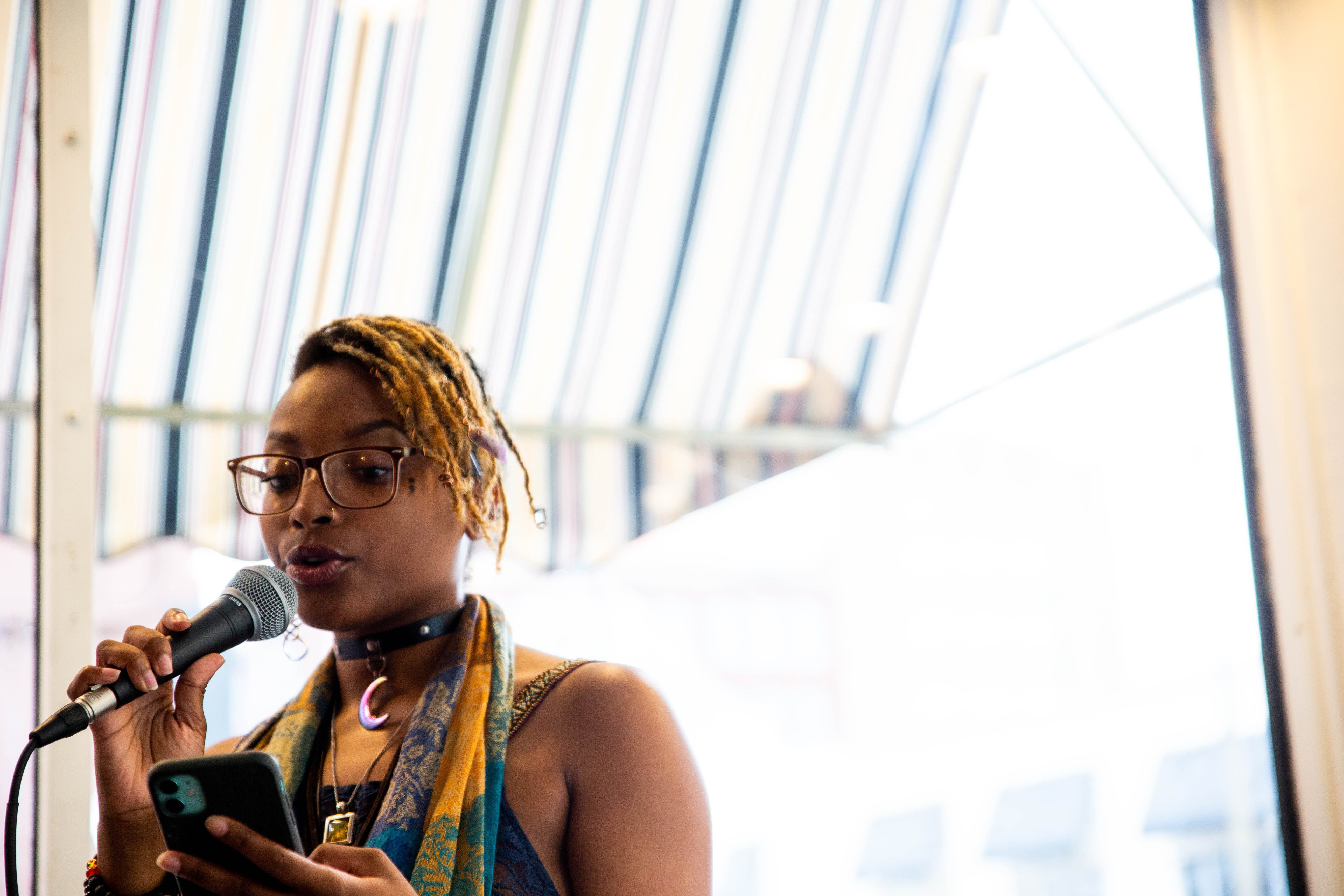 People share poetry and stories during Pride Month open mic poetry ...