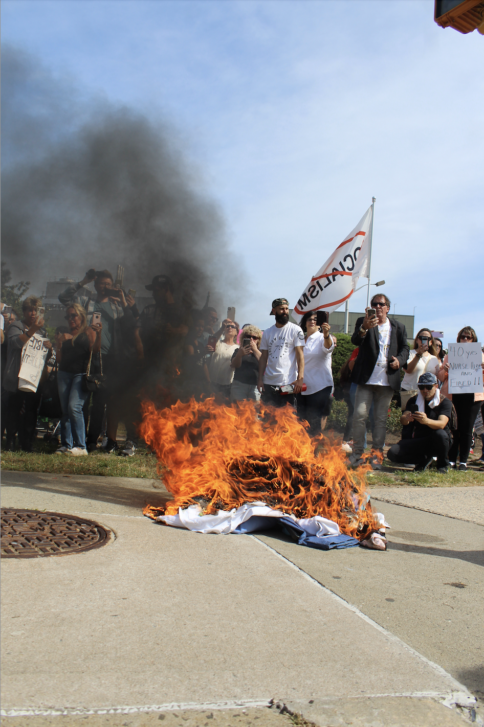 Scrubs torched, chants of non-compliance at rally against vaccine ...
